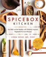 ผ้าคลุมครัว Spicebox พร้อมช้อนและเครื่องเทศบนพื้นหลังสีขาว