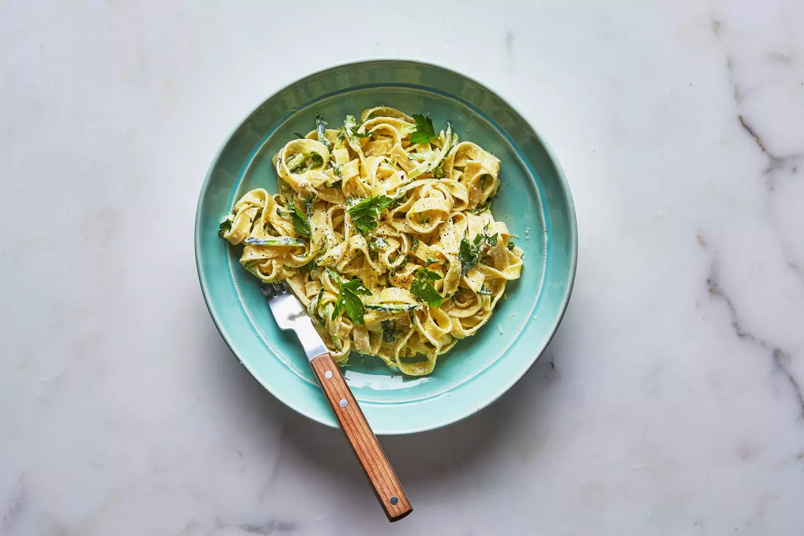 Fettuccine pẹlu sauted zucchini lẹmọọn zest ati parsley.