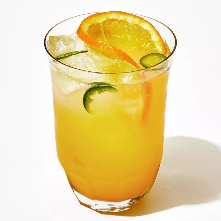 Vaso con jugo de lima naranja jalapeño en rodajas y guarnición de rodaja de naranja