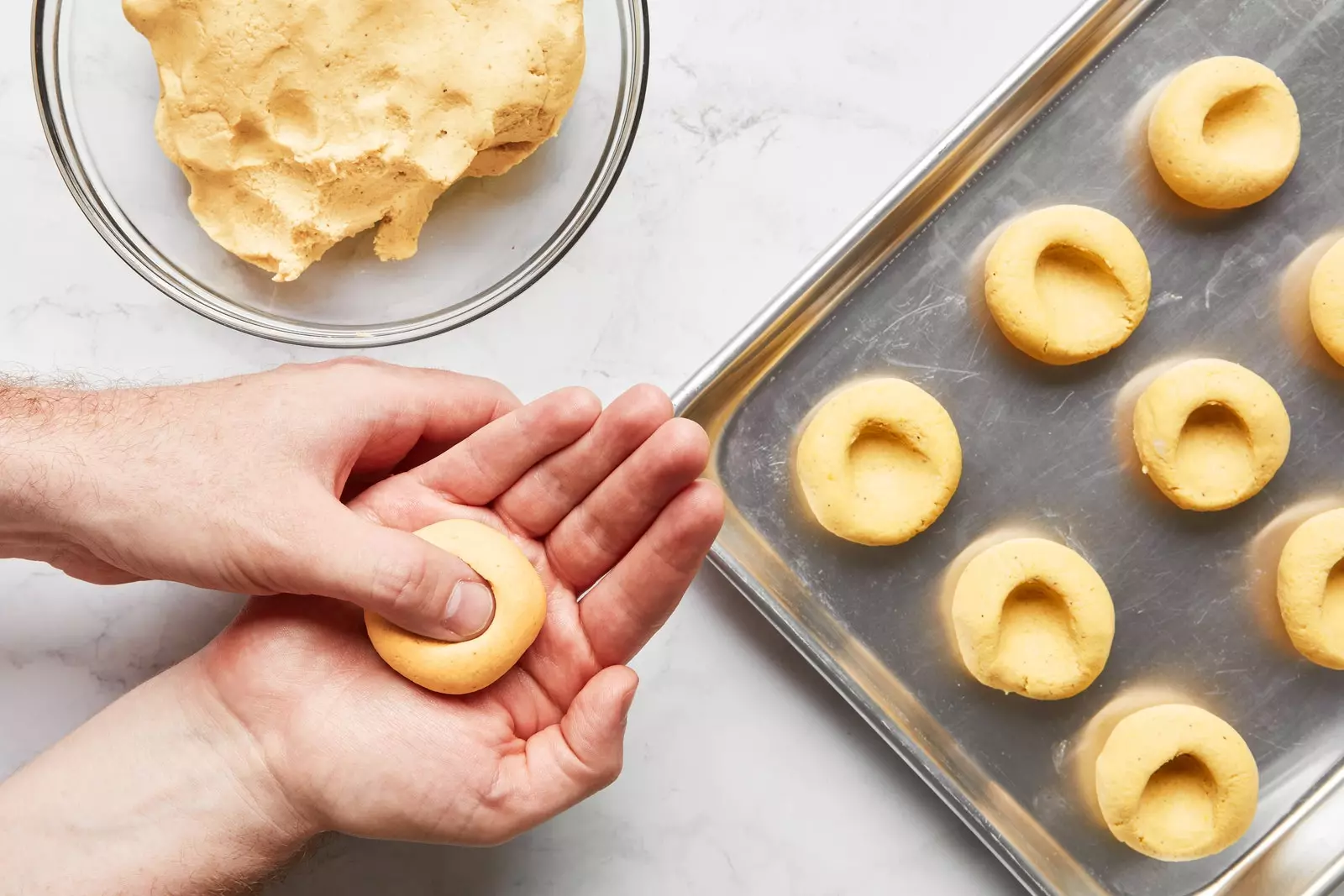 Litrato sa presko nga masa nga giporma ngadto sa chochoyotes ug gibutang sa usa ka baking pan.