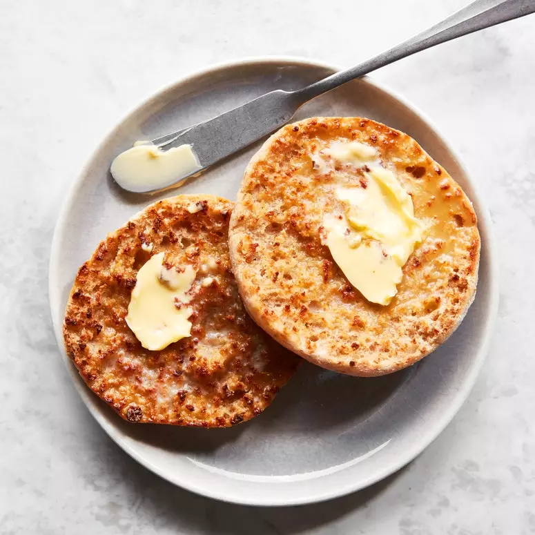 Foto van 'n geroosterde suurdeeg Engelse muffin met botter.