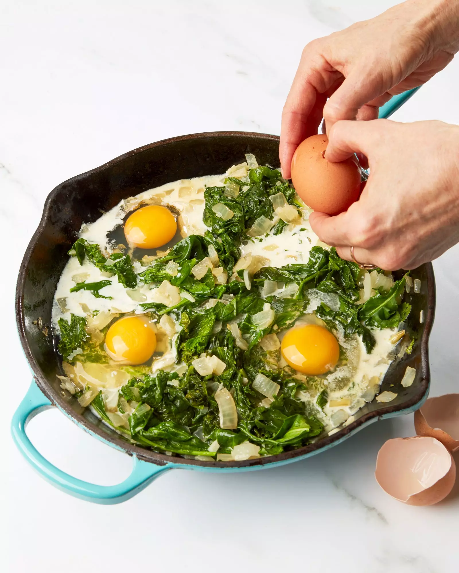 Nuotrauka, kurioje kiaušiniai sulaužomi į Peppery Creamy Greens