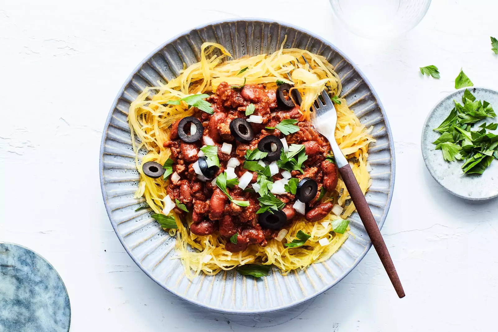 Spaghetti-Kürbis mit Truthahn-Chili auf einem Teller mit einer Gabel.