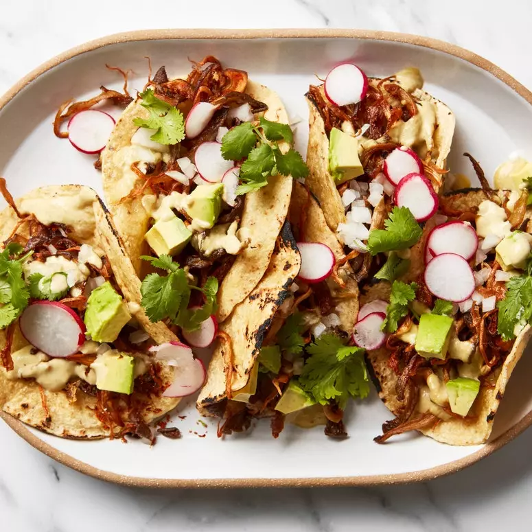 Foto de tacos de cogomelos tirados nun prato.