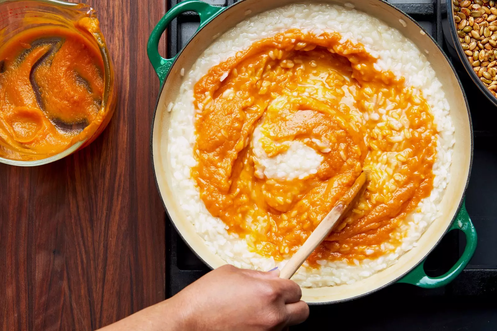 Foto einer Person, die Kürbispüree in Risotto rührt.