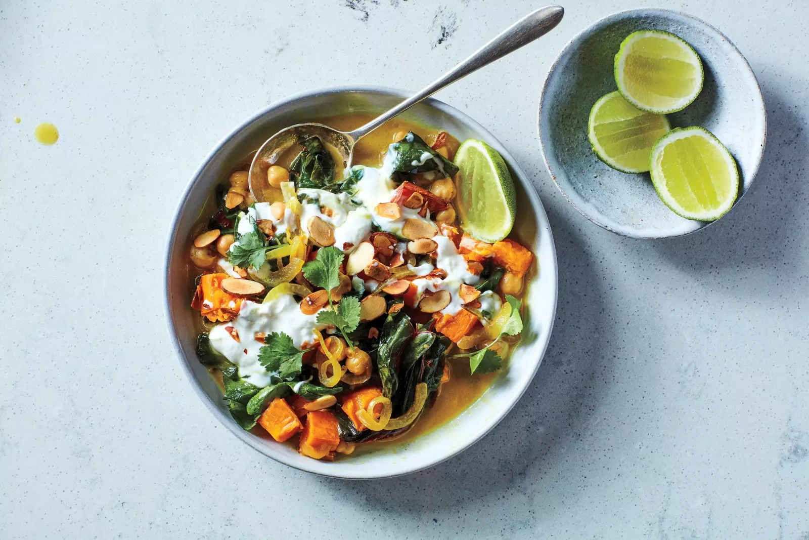 Foto von einem unserer besten Kokosmilchrezepte Kichererbsencurry mit Süßkartoffelwürfeln und Gemüse in einer Schüssel.