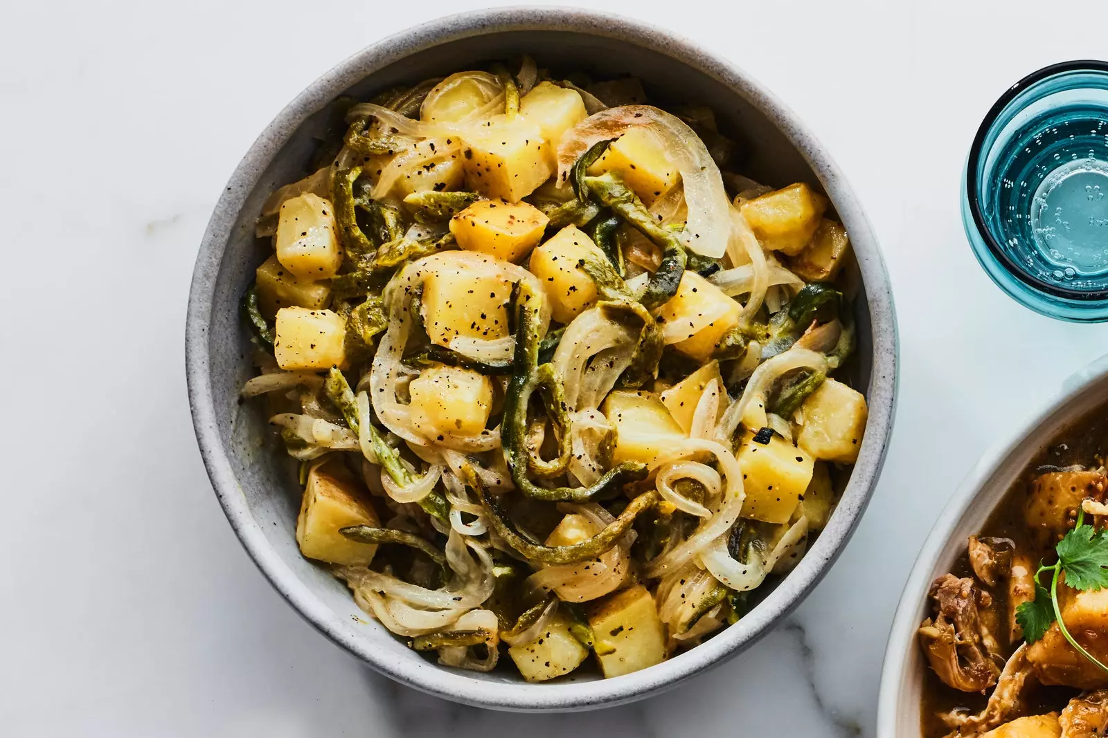 Foto einer Schale mit mexikanischen Kartoffeln, gekocht mit Poblano-Paprika und Zwiebeln.