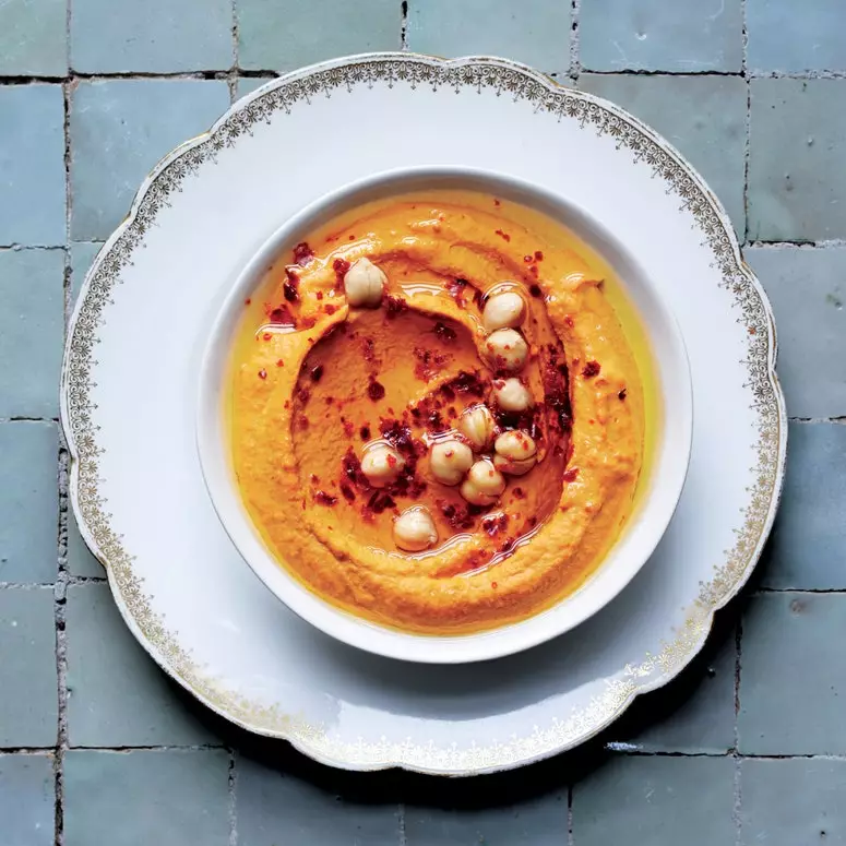 Semangkuk kecil hummus manis dan masam dihiasi dengan kacang ayam dan lada Aleppo.