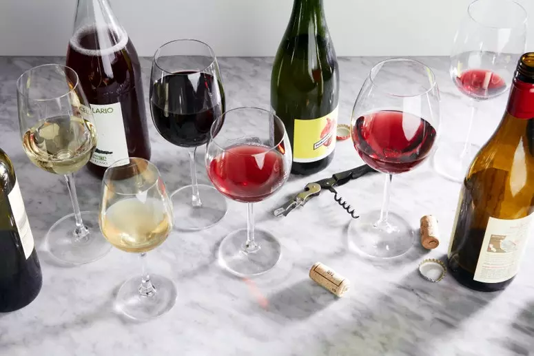Fotografija kolekcije najboljih vinskih čaša s nekoliko boca vina.