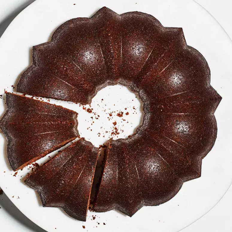 Bovenaanzicht van chocolade bundt cake op in wite plaat. Ien fan ús bêste resepten foar bundt cake.