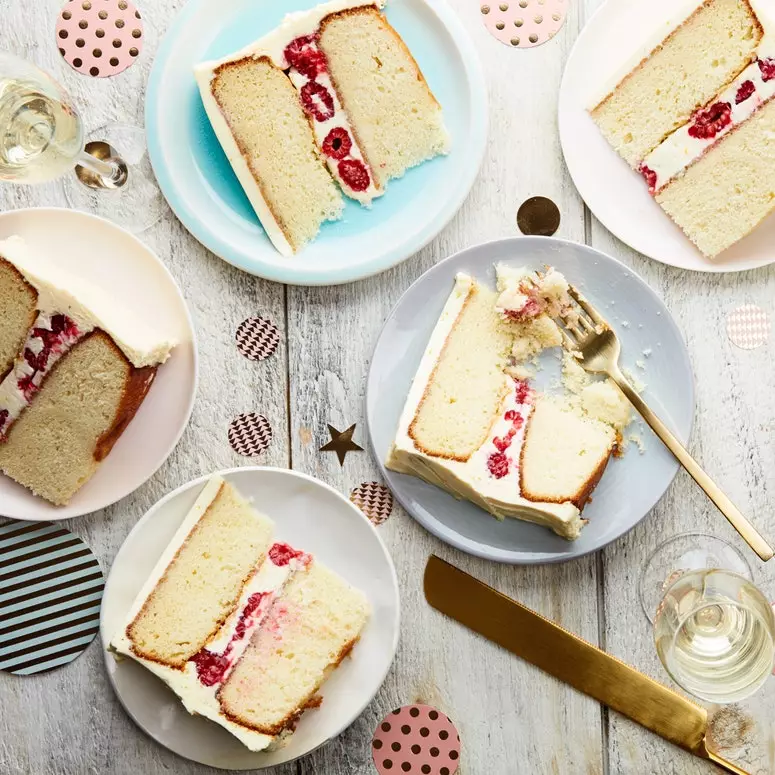 Senepe sa recipe ea classic layer cake vanillabuttermilk layer cake e tlatsitsoeng raspberry. Lilae le kuku e feletseng e bontšitsoe.