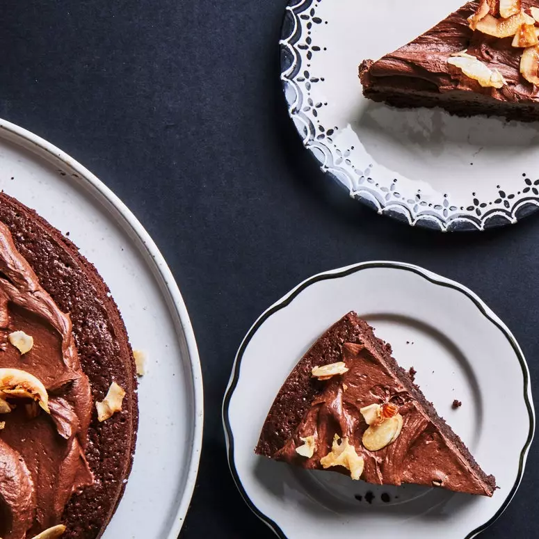 Szelet csokoládé macaroon torta kis tányérokon a maradék egész tortával egy tálra.