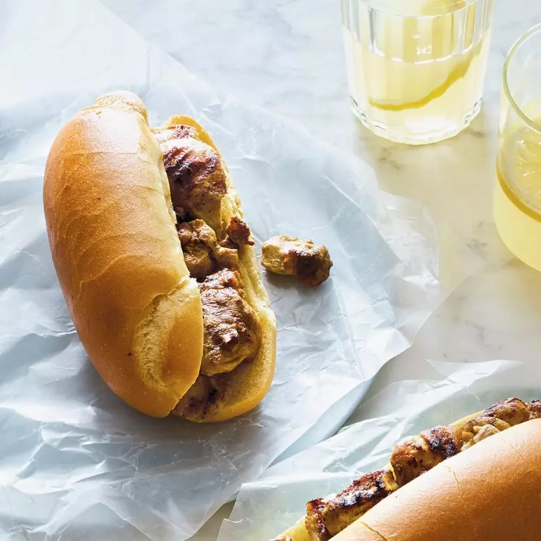 Usa ka litrato sa mga espiya sa manok sa hot dog roll sa wax nga papel.