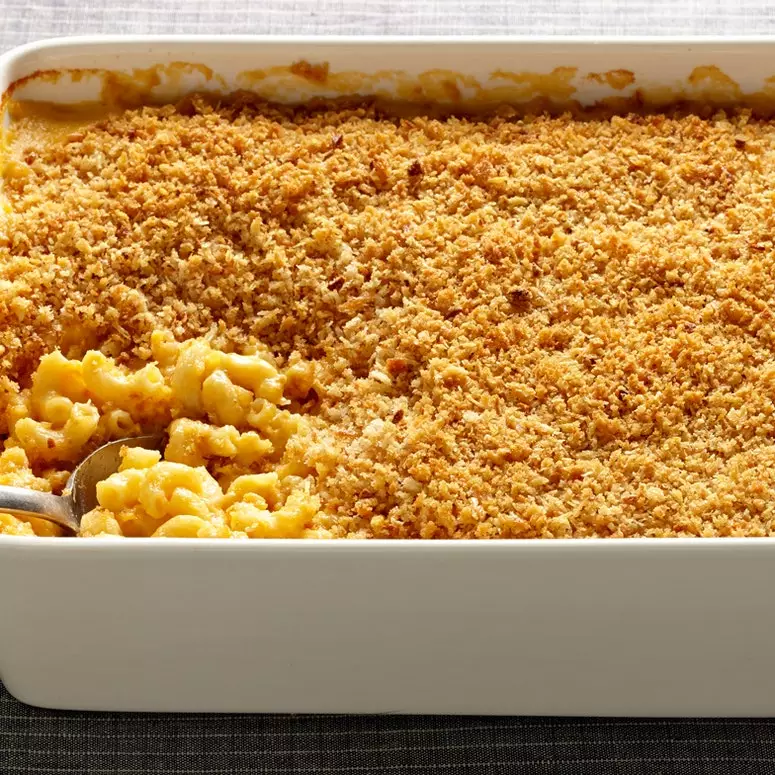 Baked macaroni en tsiis toped mei knapperige bôlekruimels yn in wite casserole skûtel mei hânfetten.