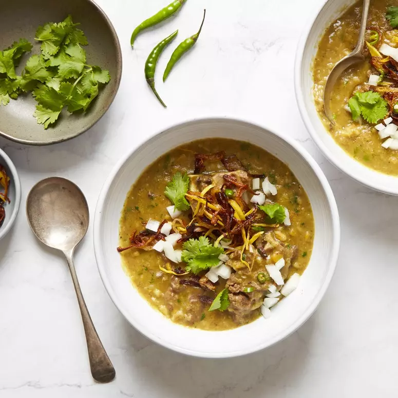 Foto ti Mouton Haleem nan yon bòl ak echalot cilantro ak jenjanm.