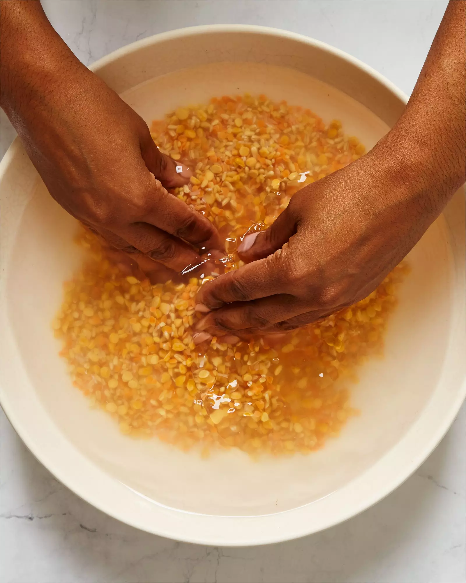 Poto campuran lentil keur dikumbah dina mangkok.