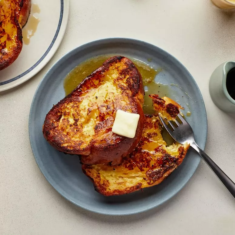 Gourmet's Buttermilk French Toast-ის რეცეპტი თეფშზე ჭიქებით ფორთოხლის წვენით და ყავით გვერდზე.