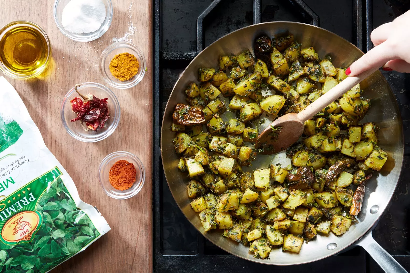 Fotografija osobe koja pravi Aloo Methi sa smrznutim listovima piskavice