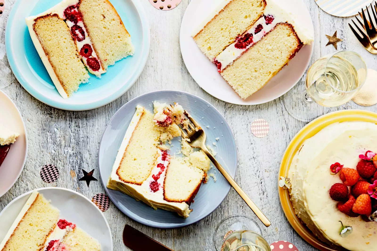 Ifoto ye-classic layer cake recipe i-vanillabuttermilk layer cake kunye nokuzaliswa kwe-raspberry. Iziqwenga kunye nekhekhe elipheleleyo libonisiwe.