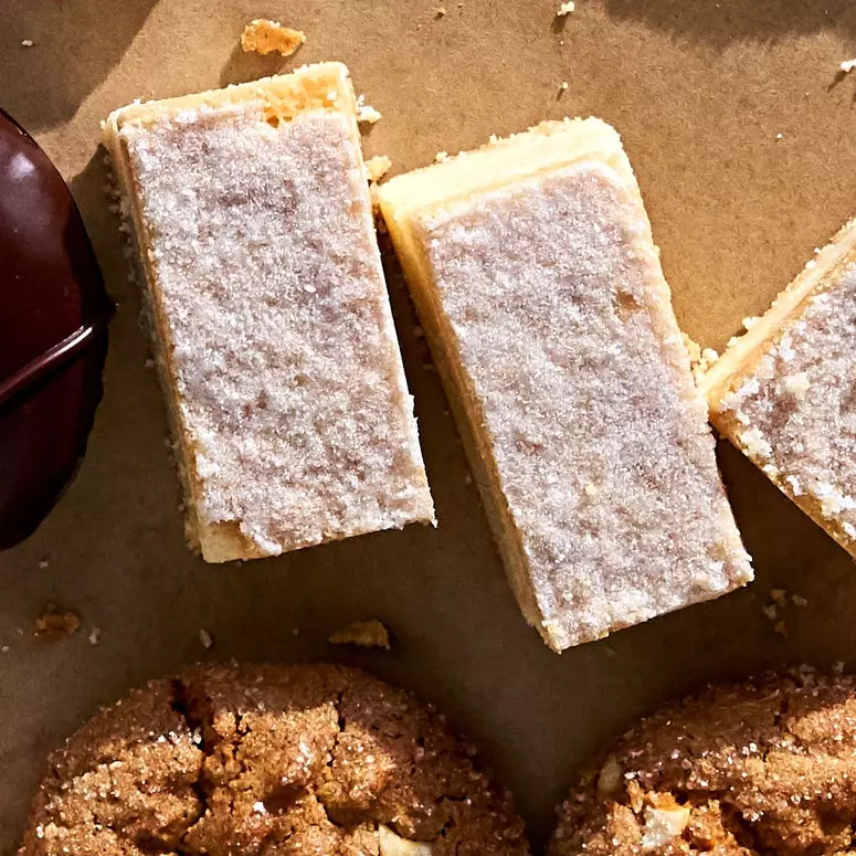 Drie rechthoekige stukjes zandkoek bedekt met witte suiker.