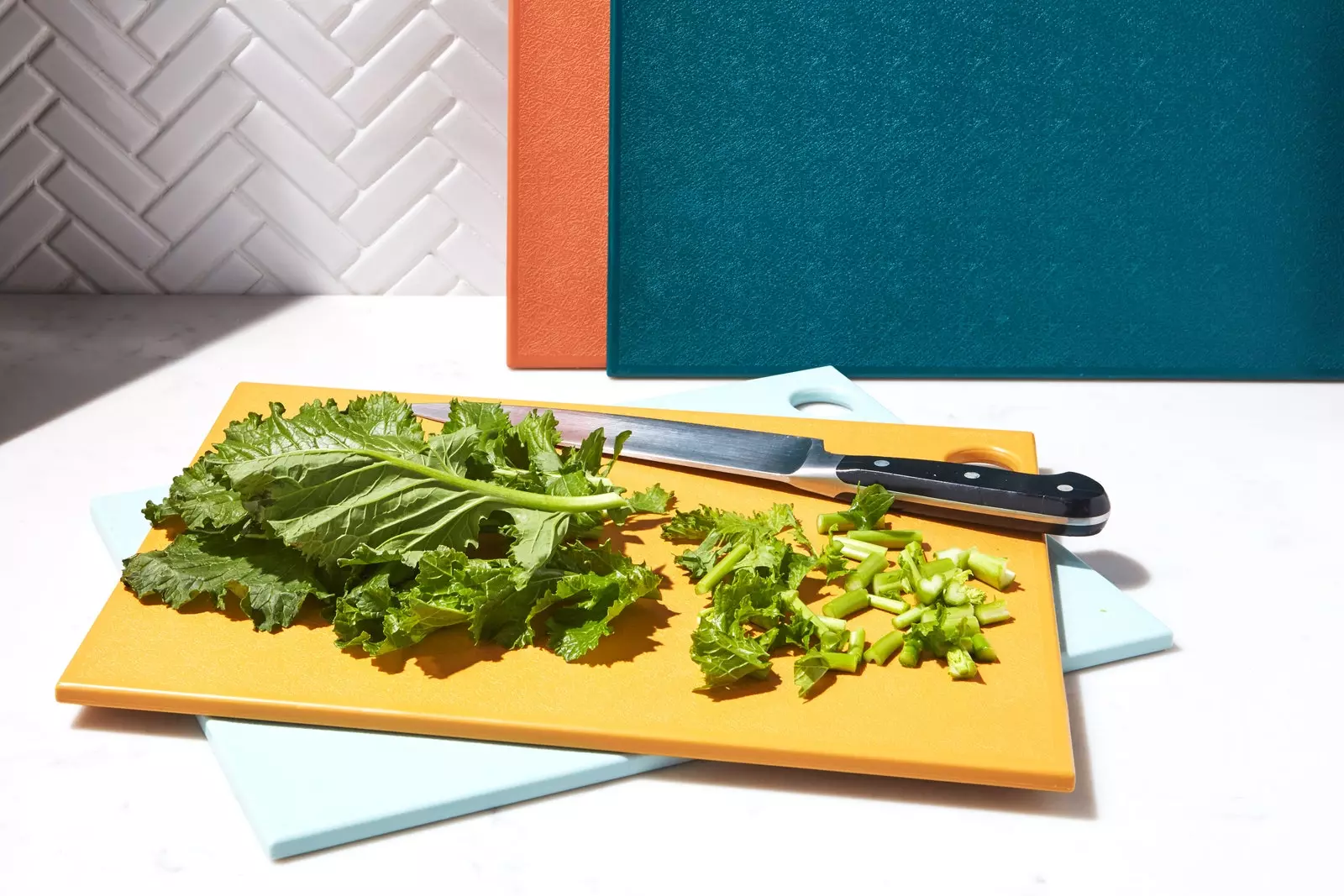 Foto av materialer skjærebrett med grønnkål og en kniv.