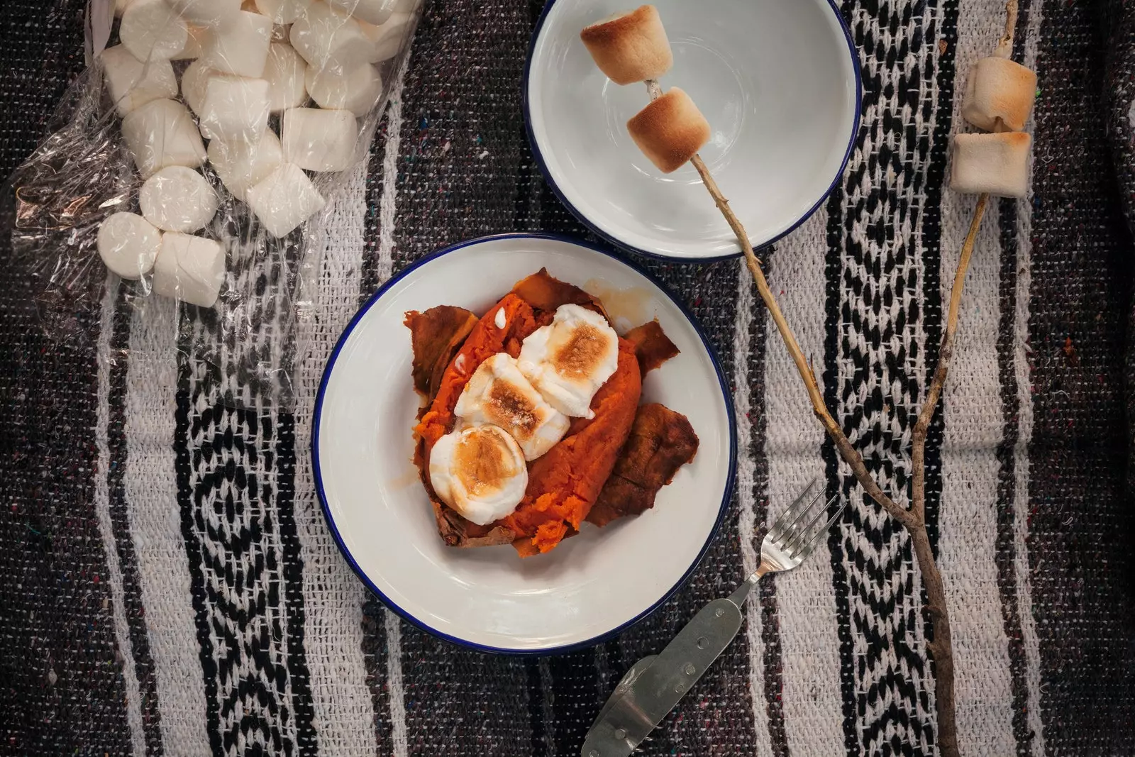 A kentang manis panggang siji mbukak lan ndhuwur karo telung marshmallows gedhe.