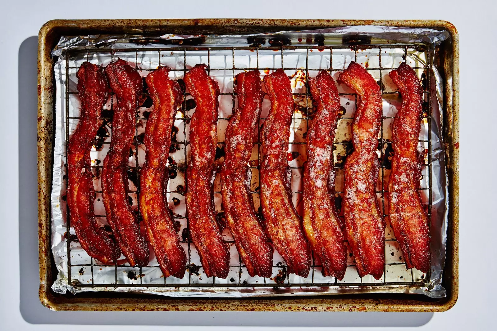 Nagluto nga bacon sa usa ka wirerack sa usa ka foillied sheet tray.