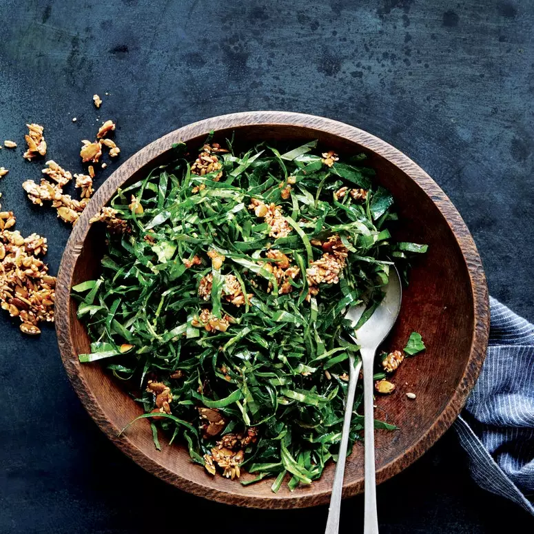 Usa ka salad sa collard greens nga gipaibabaw sa luya ug halang nga liso nga brittle sa kahoy nga panaksan.