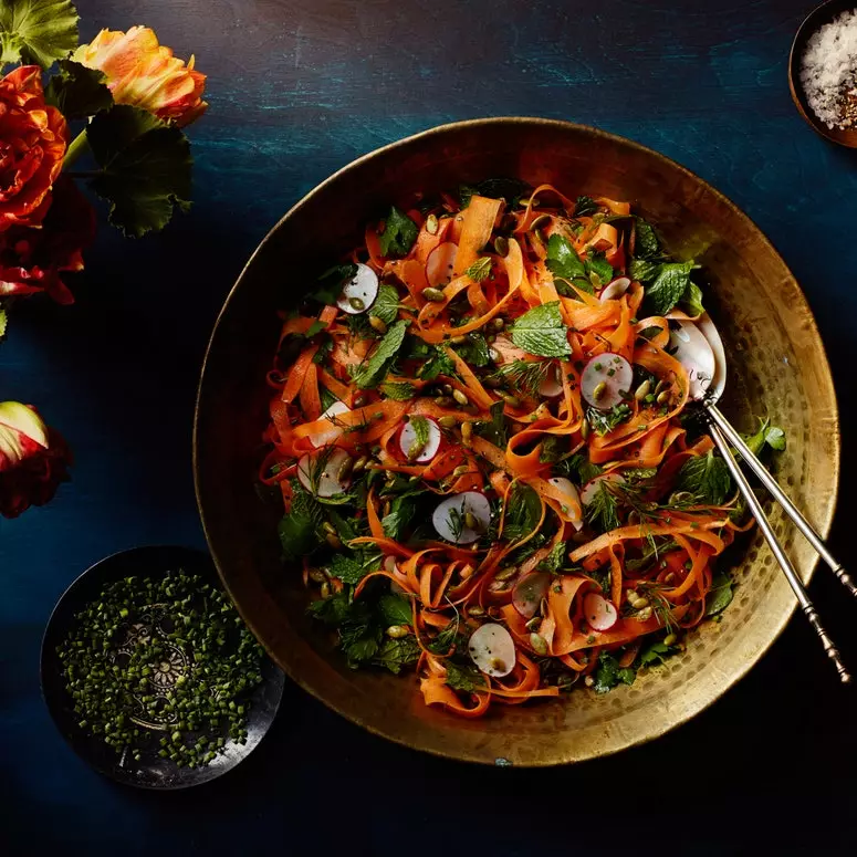 Salade van geschaafde wortel en radijs met kruiden en geroosterde pompoenpitten