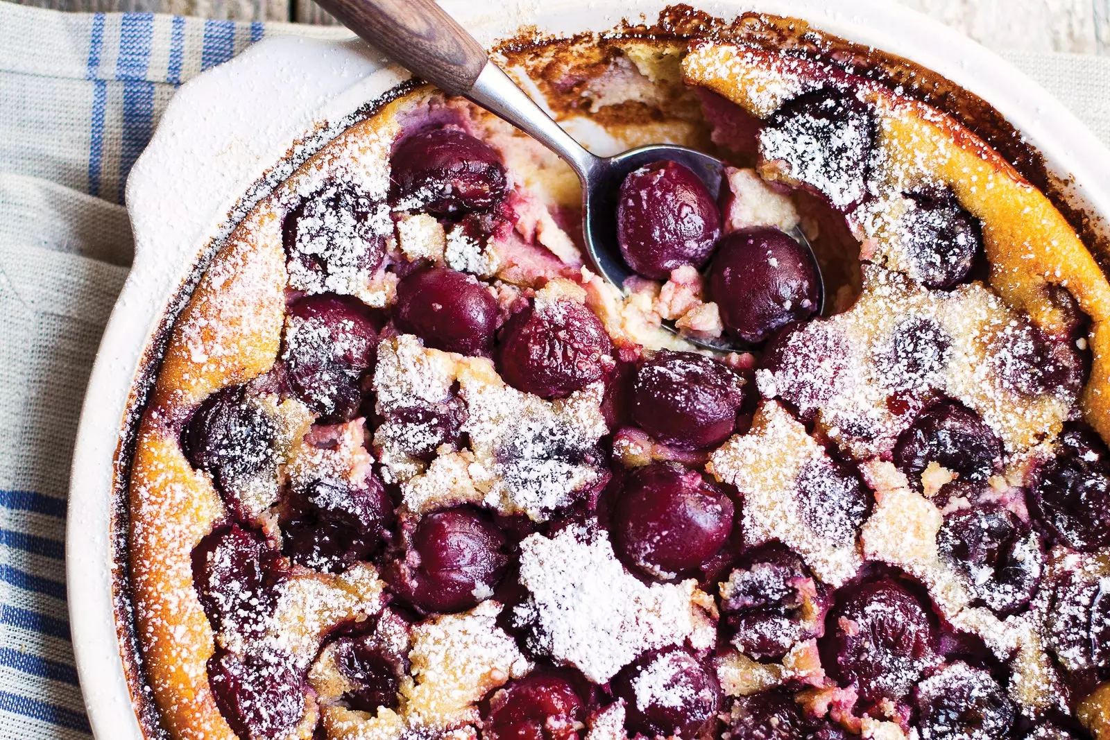 Čerešňový recept na cmarový clafoutis posypaný práškovým cukrom.