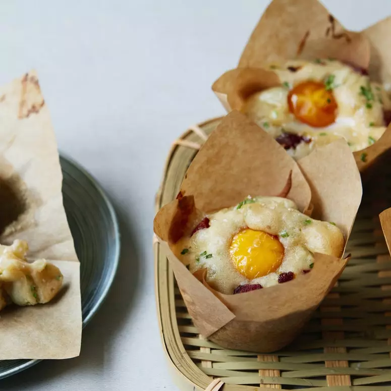 Papierové vložky plnené palacinkovými vaječnými chlebovými muffinmi so žĺtkom zapečeným na vrchu každej plus slaninkou a pažítkou...
