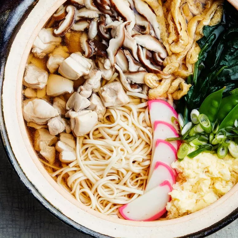 Otu ite ụrọ ejiri aka abụọ juputara na udon ọkụkọ spinach ero tofu na akwa.