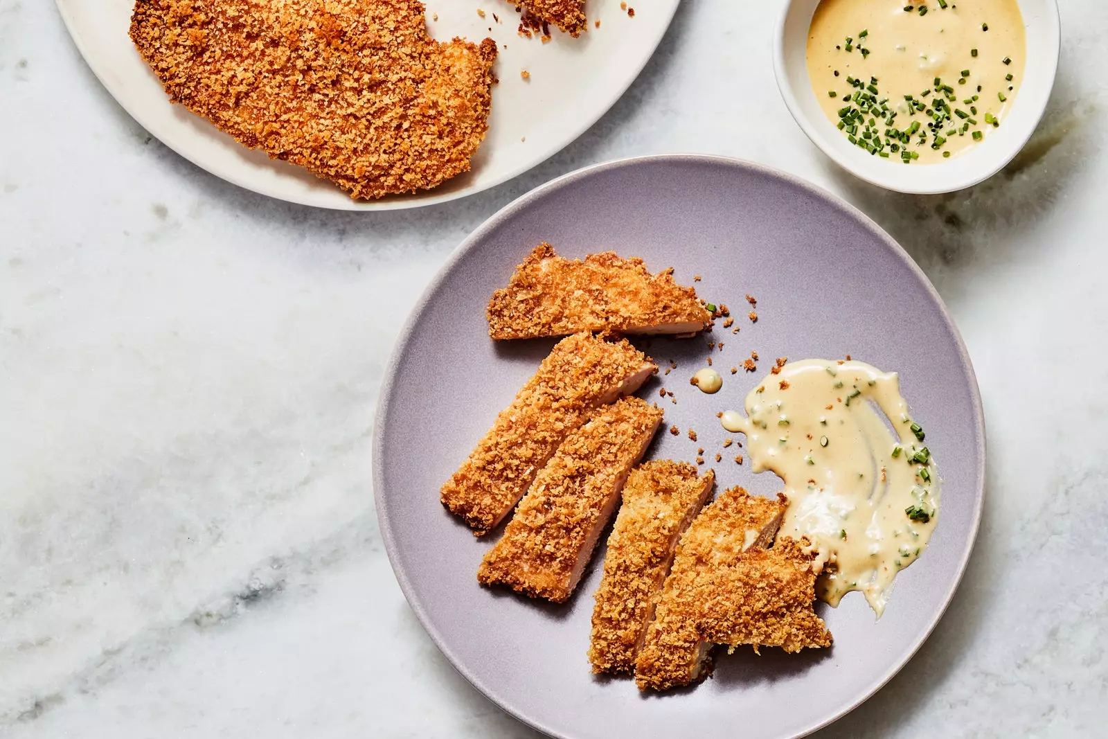 Panko-bedekte hoender met pittige mayo-dip op 'n bord.