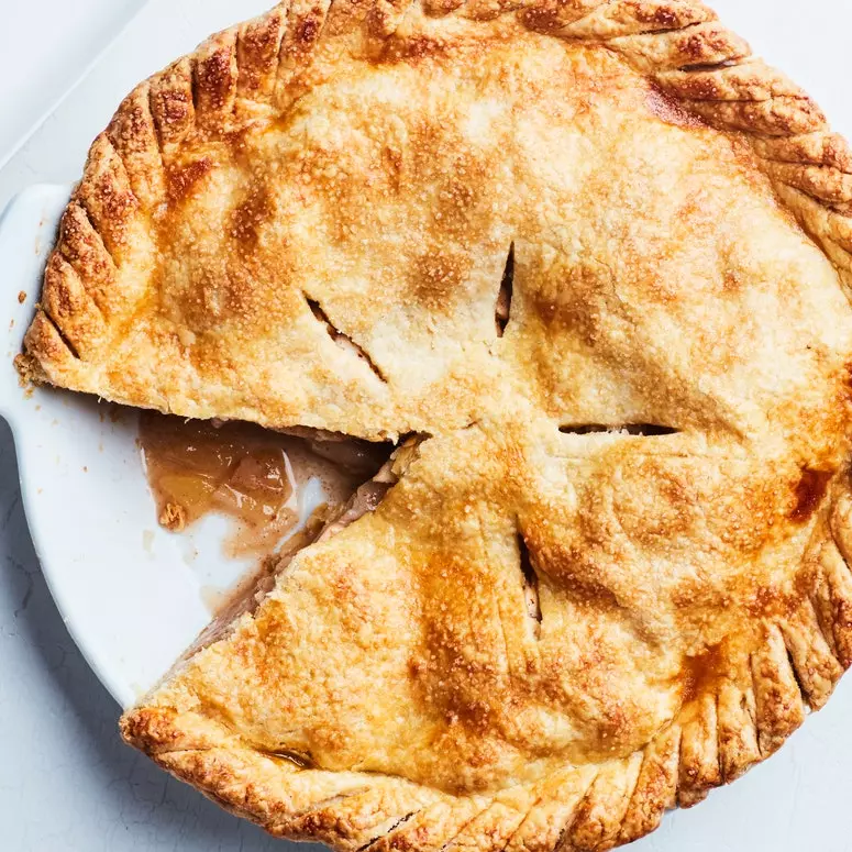 Классический яблочный пирог на сковороде с одним удаленным кусочком.