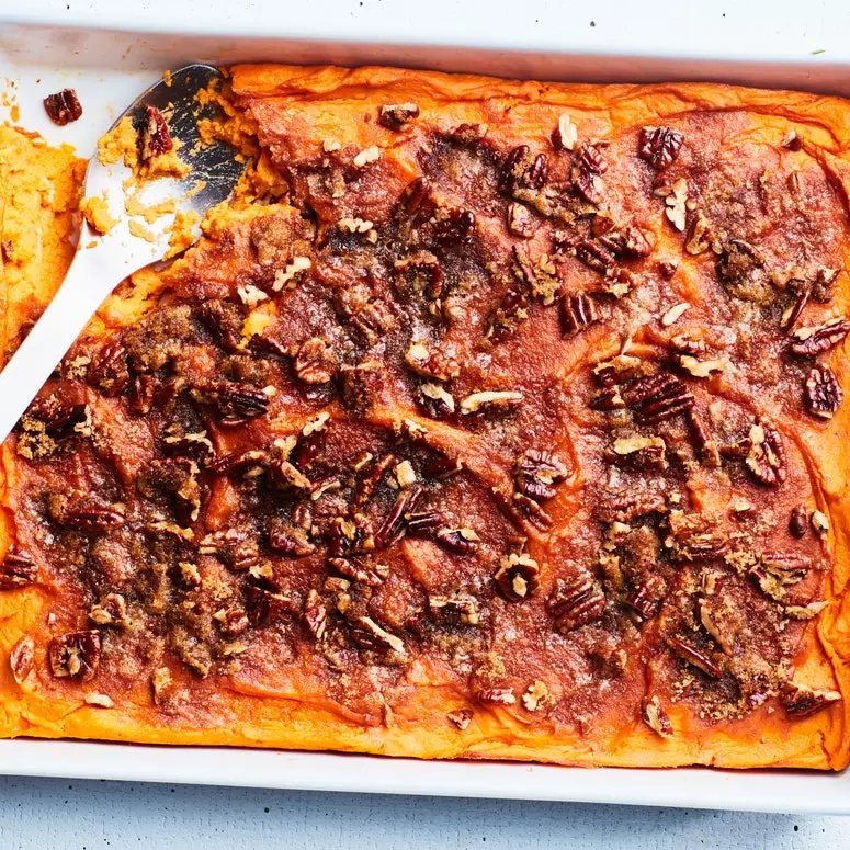 Un plat blanc de 13x9 polzades amb moniato al forn pur amb una cobertura de pacanes.