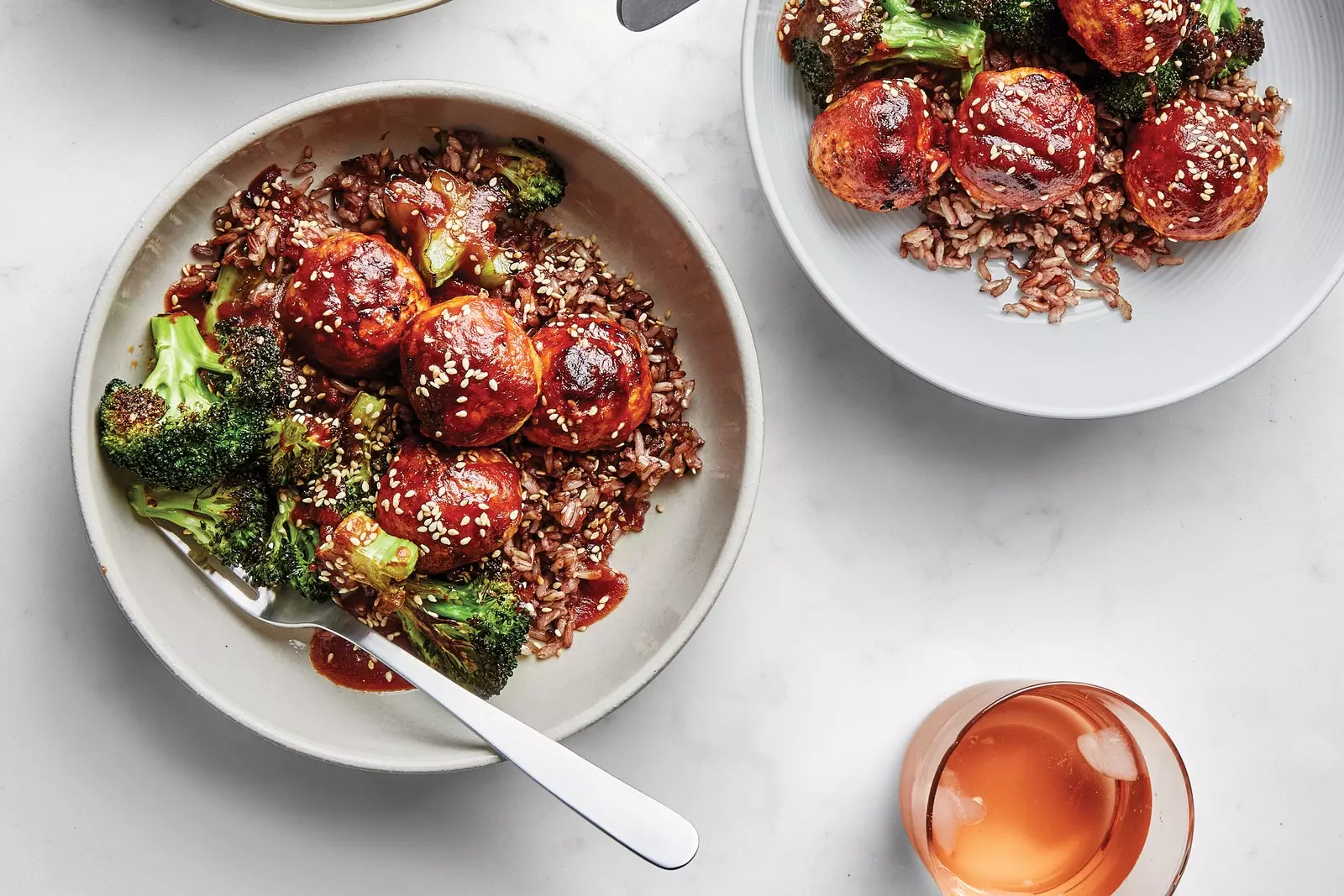 Zakudya zokhala ndi ma meatballs onyezimira komanso florets wa broccoli wowotchedwa.