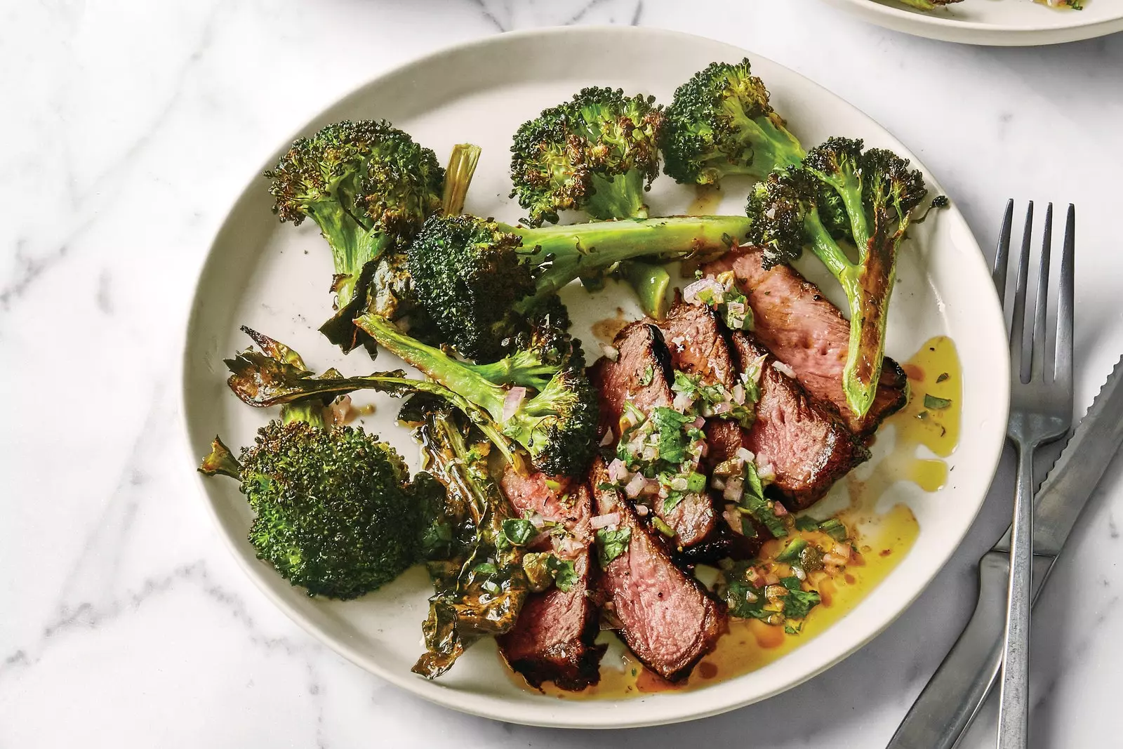 Tiki le steak ma le broccoli mu i luga o se ipu pa'epa'e fa'afefeteina i le salsa verde.