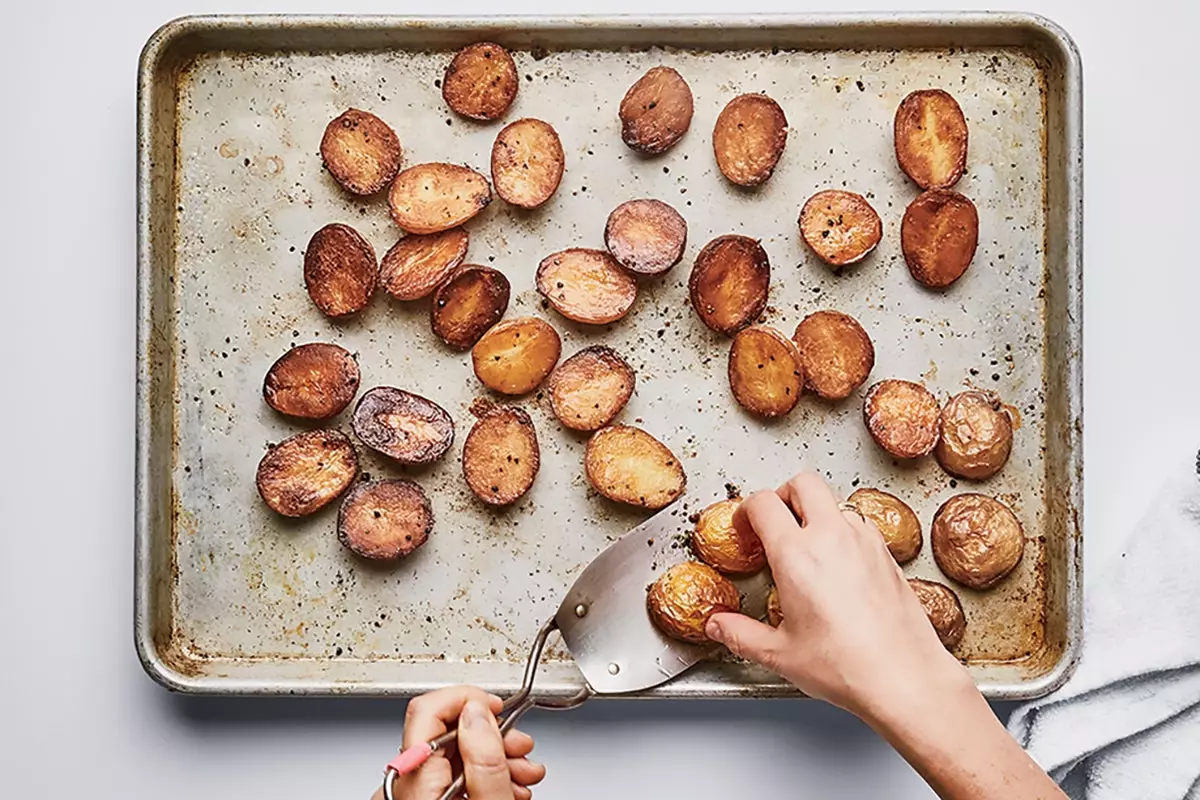 Foto van Geroosterde Aardappelen op Panspatel die aardappels verwijdert.