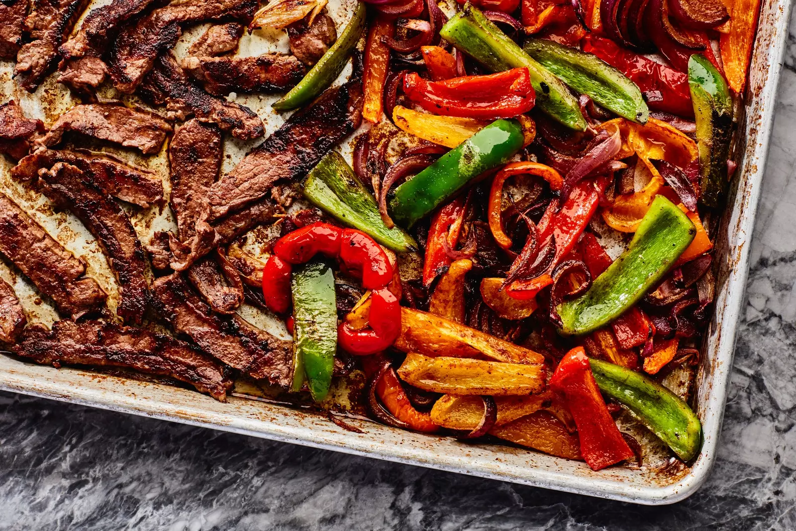 Steak dan paprika dipanggang di atas loyang.