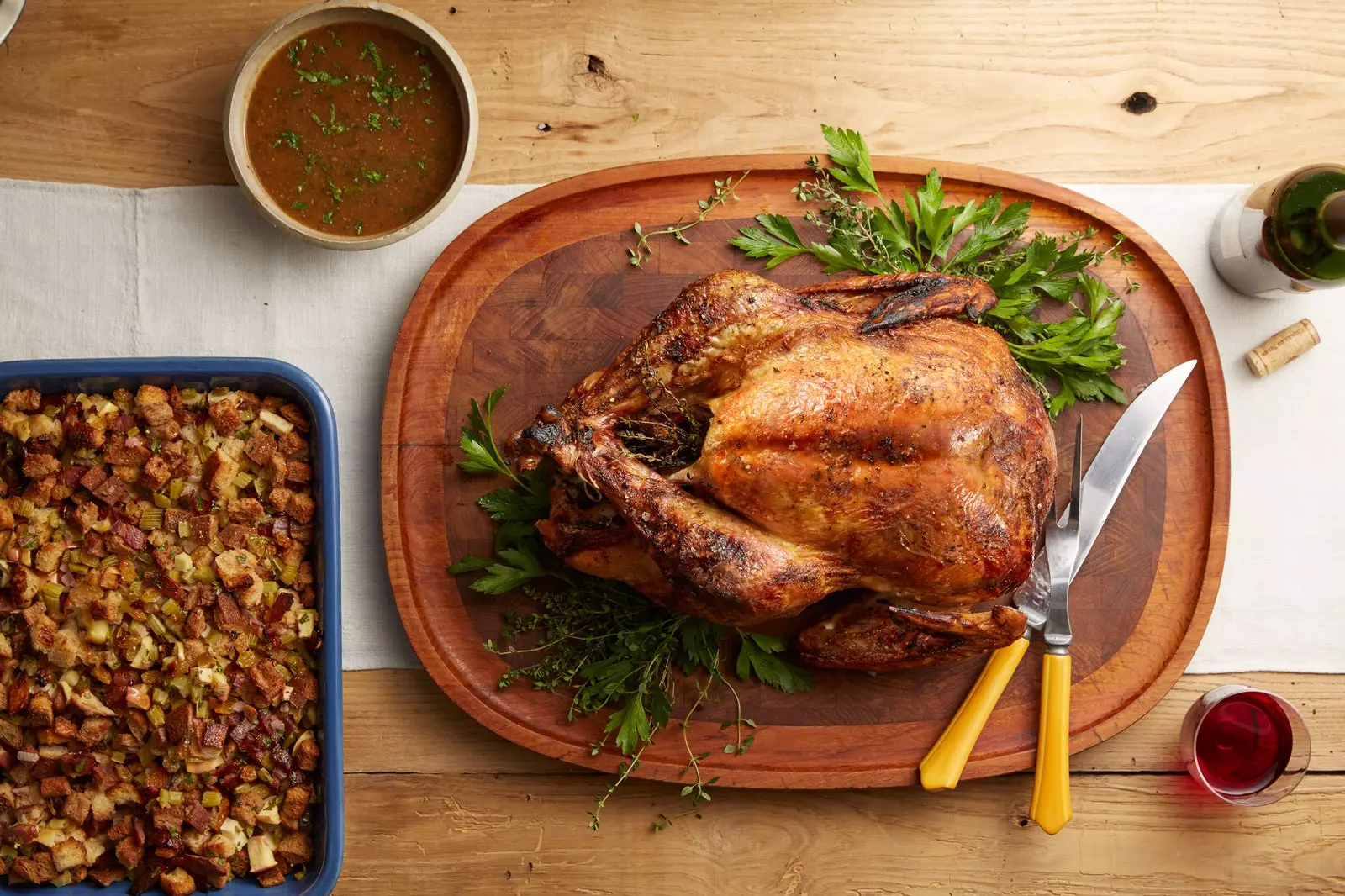 GarlicAioli Roasted Turkey with LemonParsley Au Jus នៅលើចានរាងសំប៉ែតក្បែរម្ហូបដុតនំដែលពោរពេញទៅដោយ Thanksgiving...