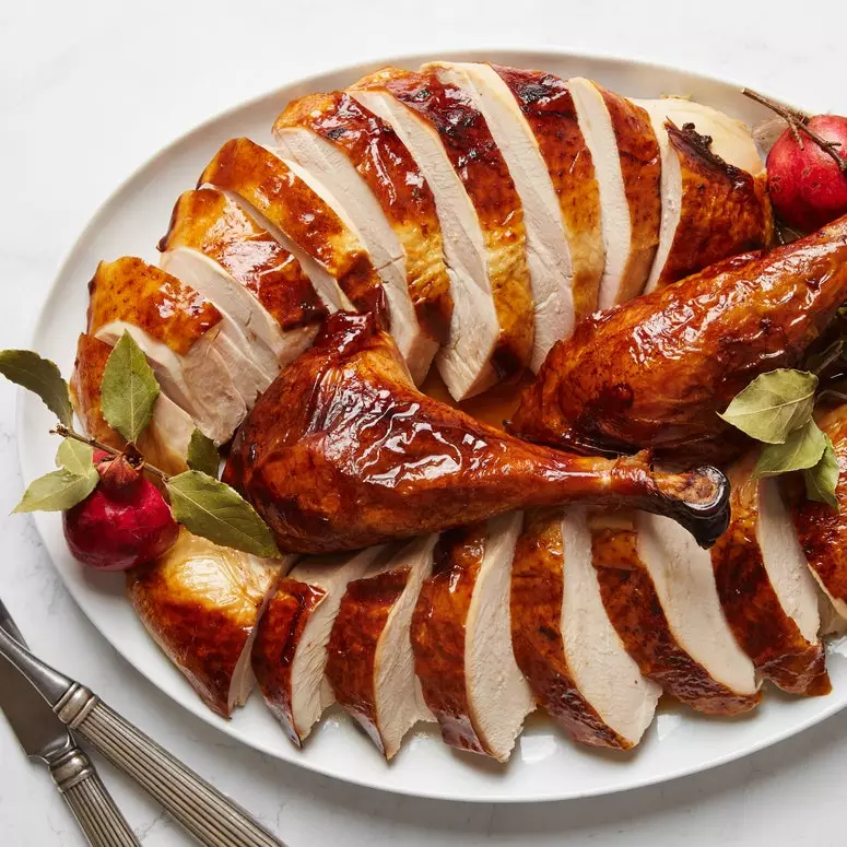 Thanksgiving turkey Recipe A roasted qaib ntxhw hlais rau hauv daim thiab feathered nyob ib ncig ntawm lub platter nrog ob txhais ceg hauv ...