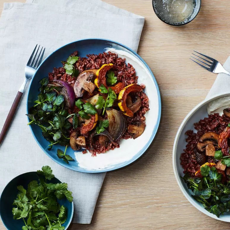 Két tál piros quinoa fűszeres squash gombával és zöldekkel.