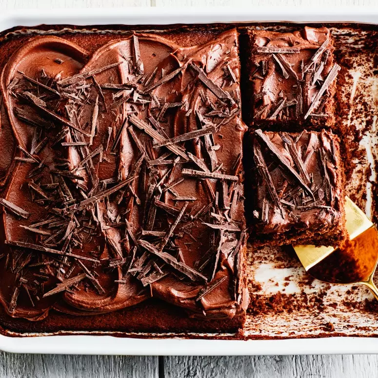 Bolo de chocolate Onebowl nunha fonte rectangular branca cunha rebanada nun prato con borde azul ao lado.