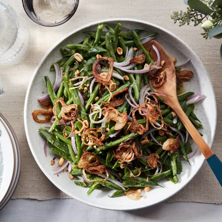 Parhaat kiitospäiväsalaattireseptit Murskattu vihreä papu salaatti, jonka päällä on paistettua salottisipulia ja raakaa punasipulia.