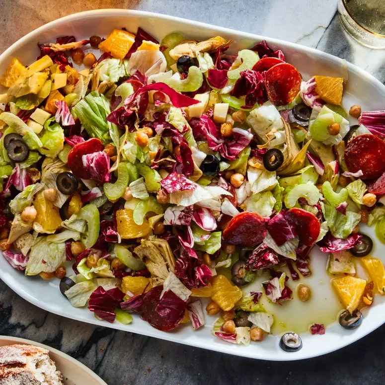 Salade hachée sur plateau avec pain sur le côté.