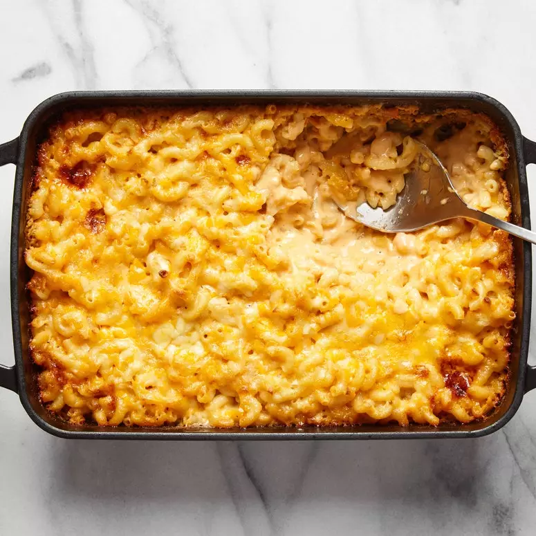 Photo de macaroni au fromage dans un plat allant au four avec une cuillère.