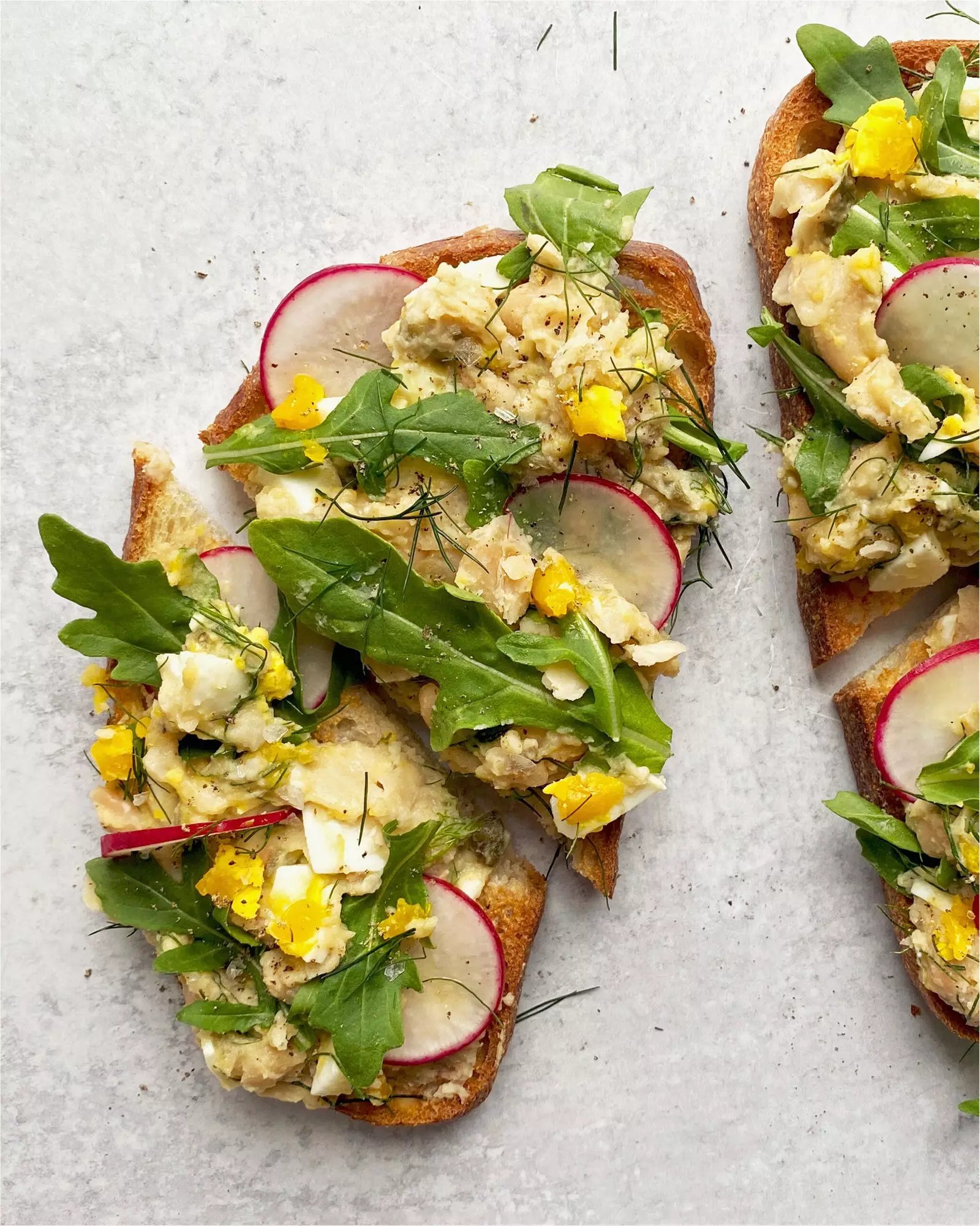 Setšoantšo sa mahe a pholileng a nang le arugula radish le dill holim'a selae sa toast.