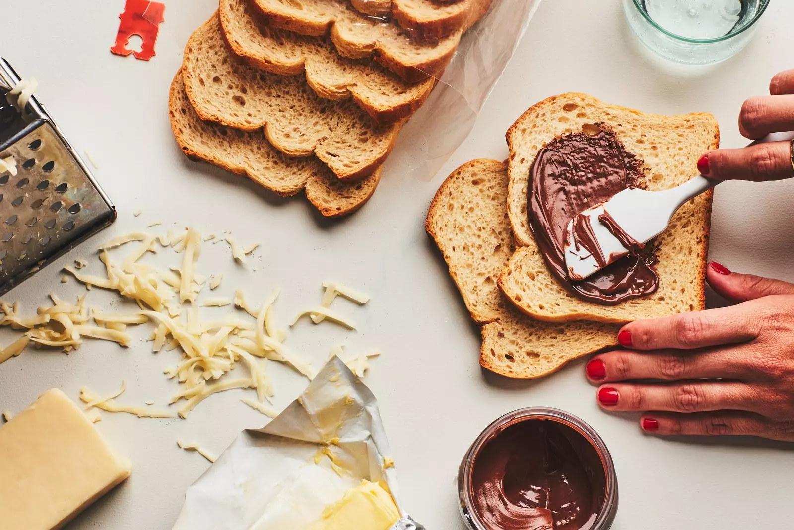 Nutella este întinsă pe pâine brânză rasă pe fundal.