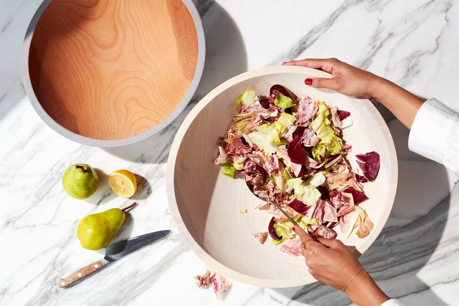 Foto fan twa grutte houten saladekom dy't brûkt wurde om radicchio-salade te meitsjen.