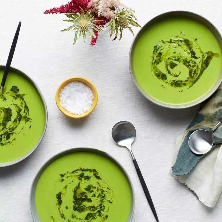 Tre ciotole di zuppa di purè verde brillante condite con vortici di un olio verde scuro.